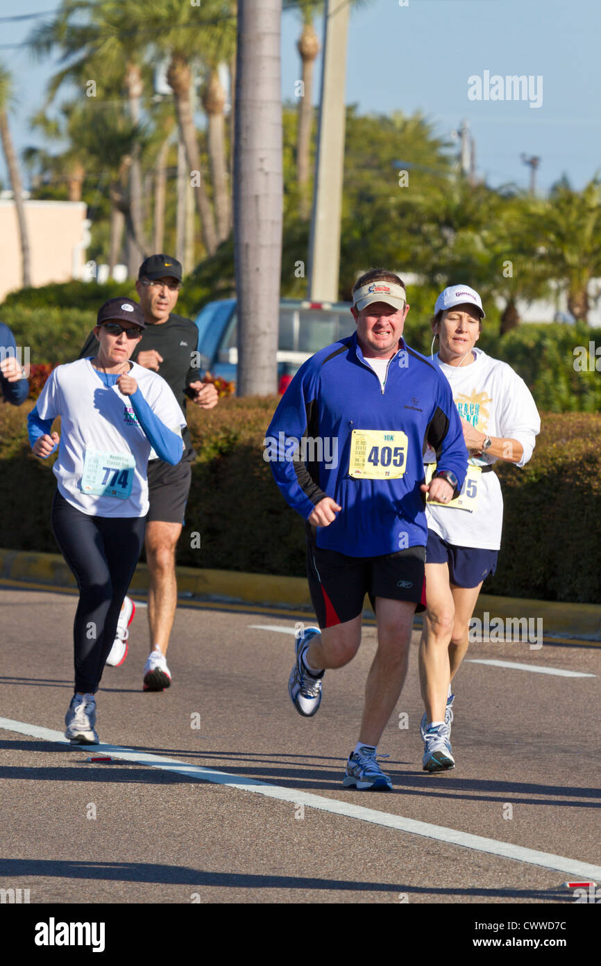 Men and women running in 5k and 10k run on streets of St. Pete Beach ...