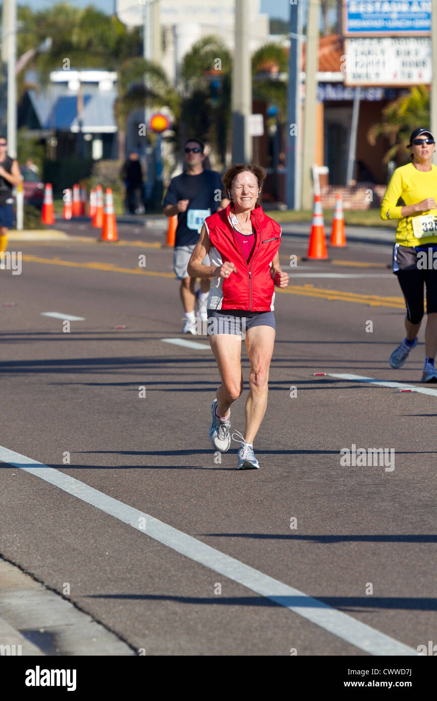 Woman running in 5k and 10k run on streets of St. Pete Beach, Florida ...