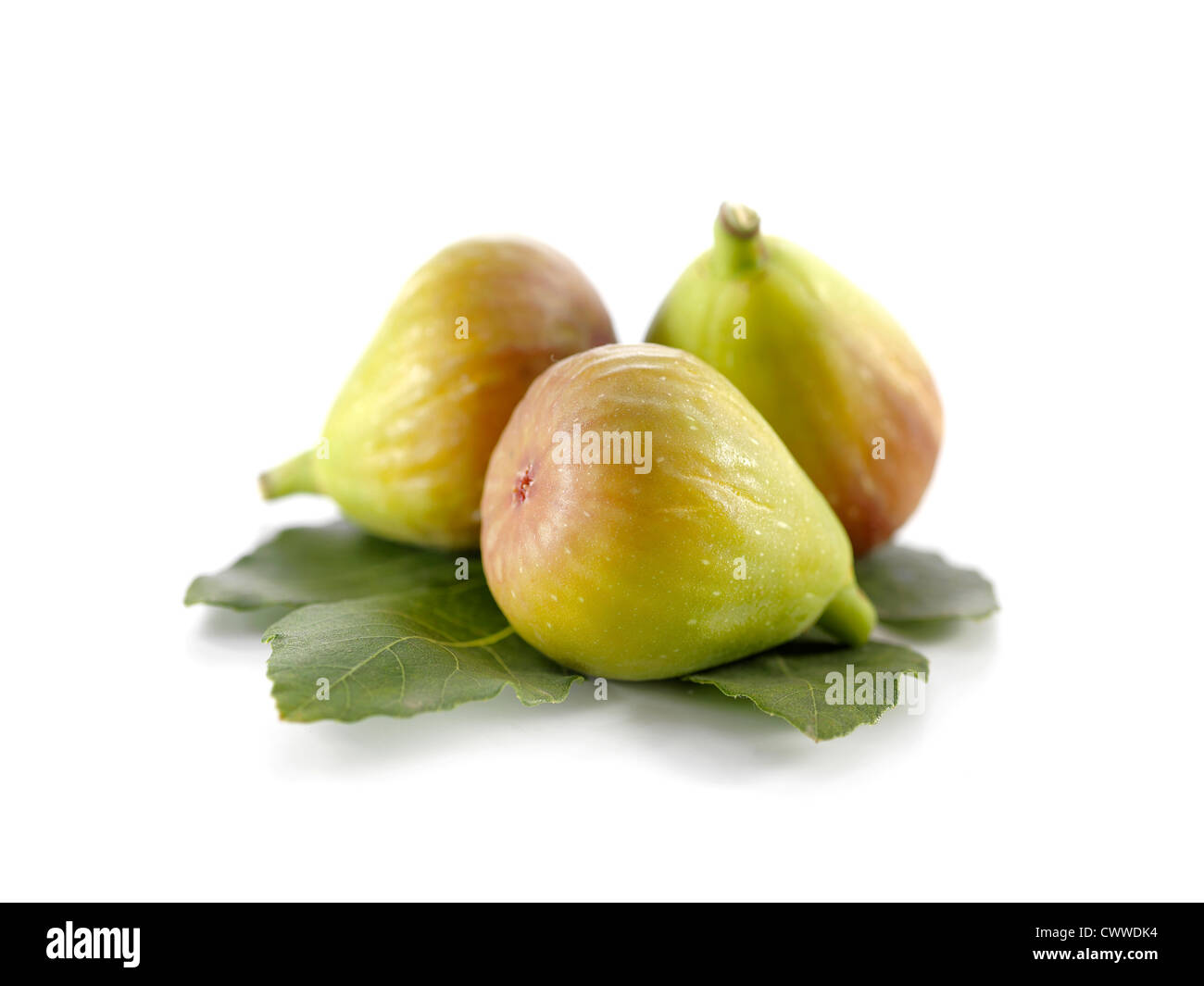 three figs with leaves on white background Stock Photo - Alamy
