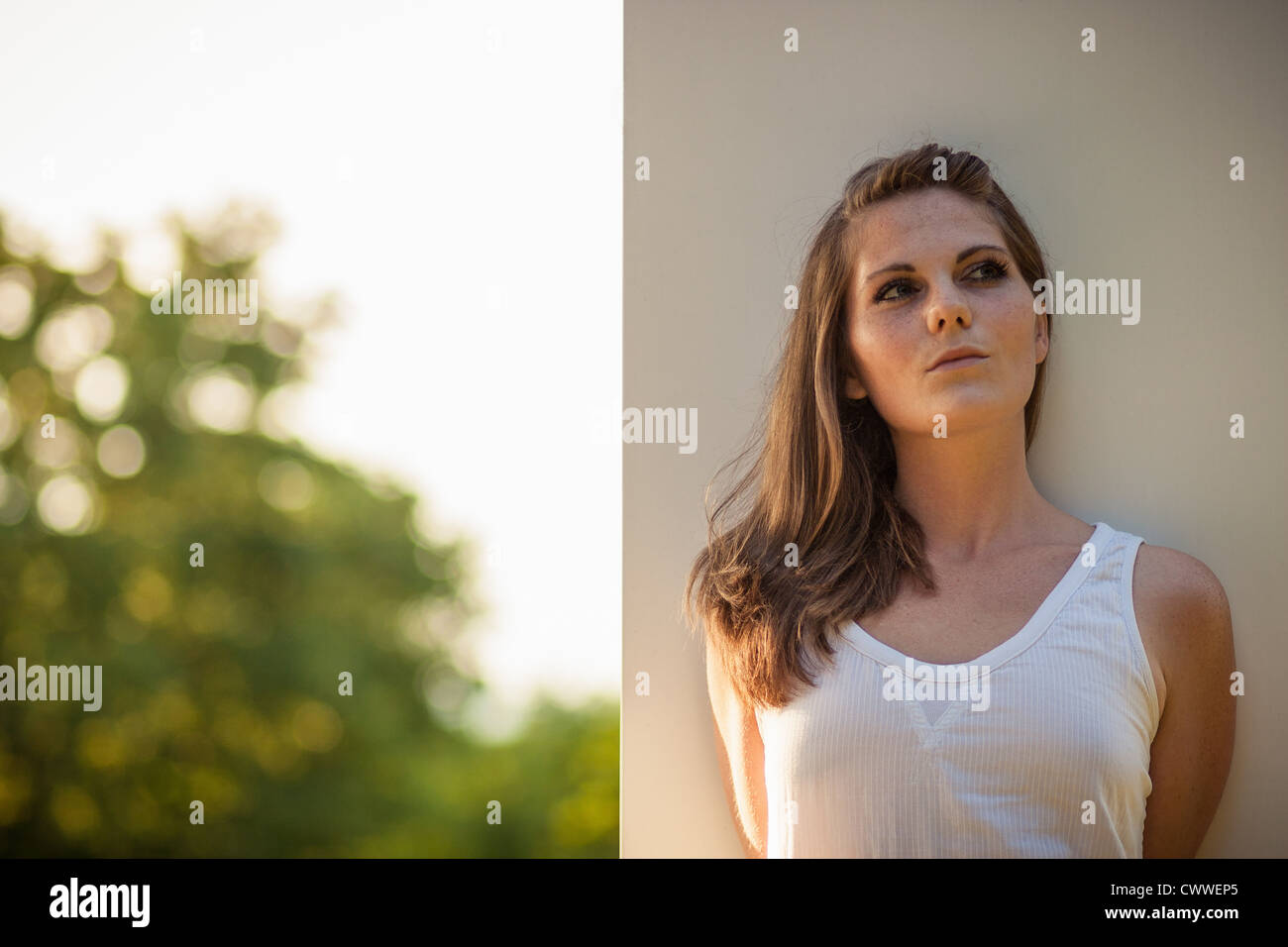 Woman leaning against wall outdoors Stock Photo - Alamy