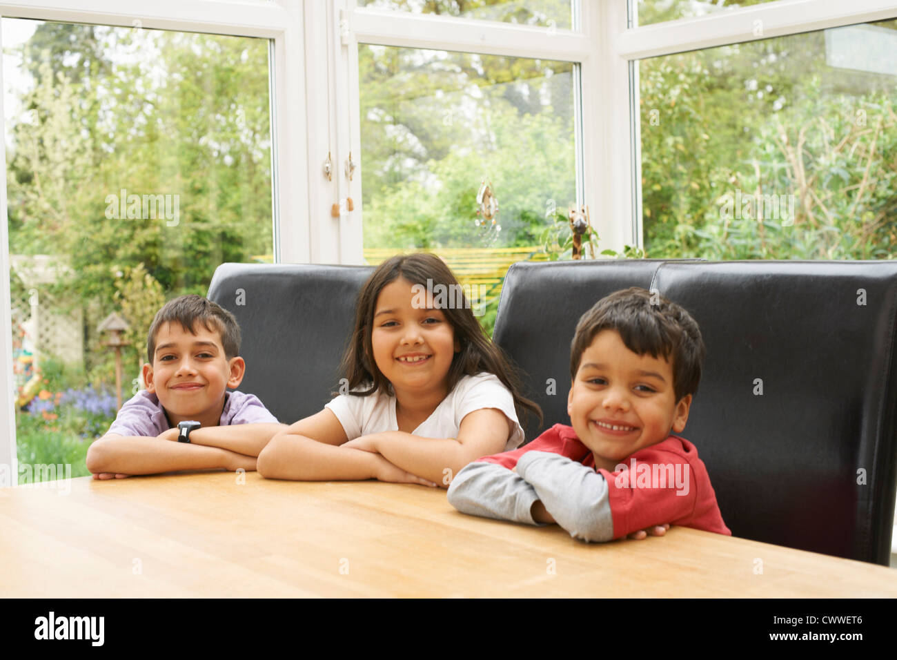 Children smiling at table Stock Photo - Alamy