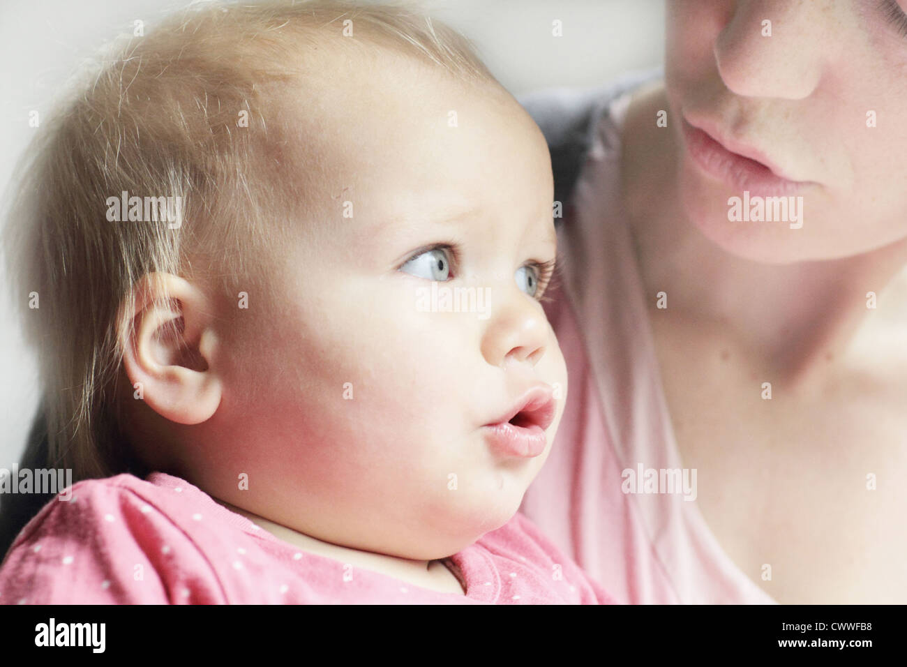 Mother holding cooing toddler Stock Photo - Alamy