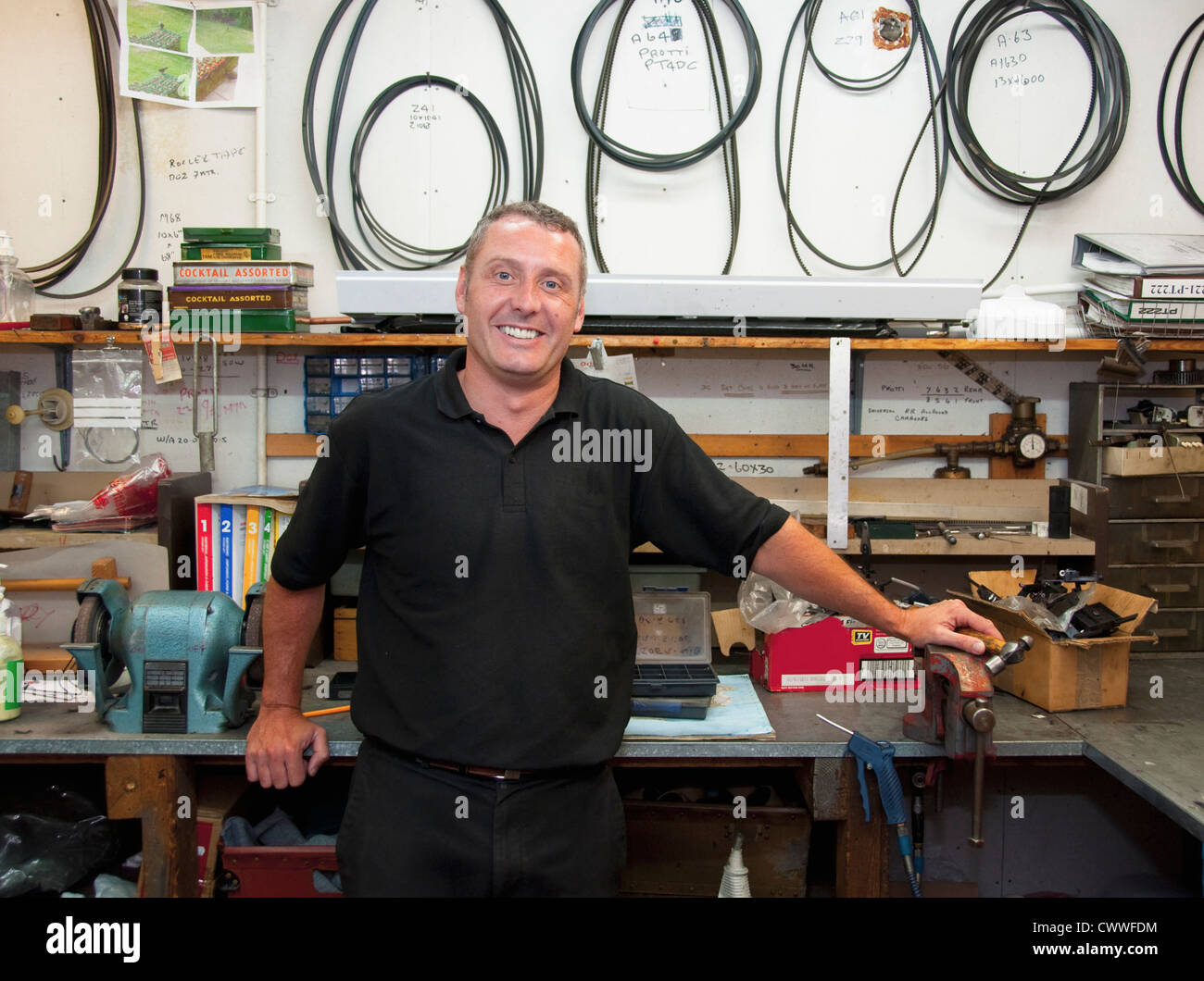 Worker smiling in workshop Stock Photo - Alamy