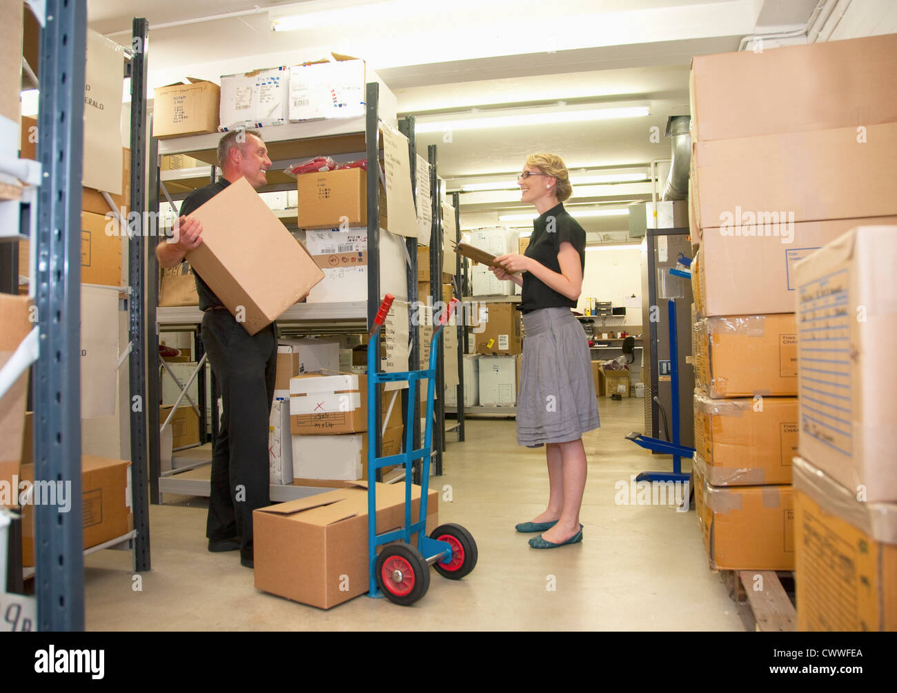 Workers talking in warehouse Stock Photo - Alamy