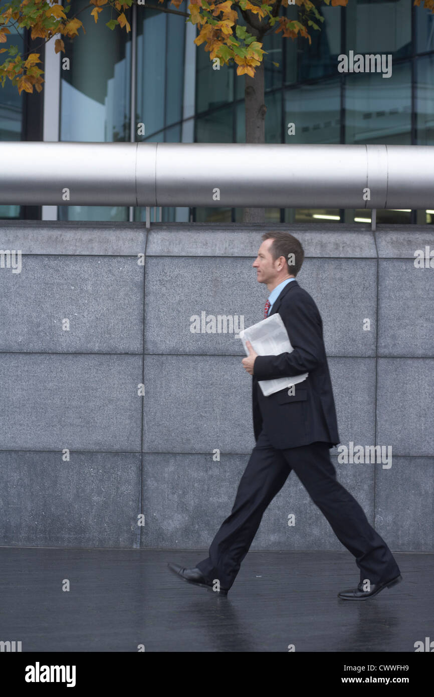 Businessman carrying paper outdoors Stock Photo - Alamy