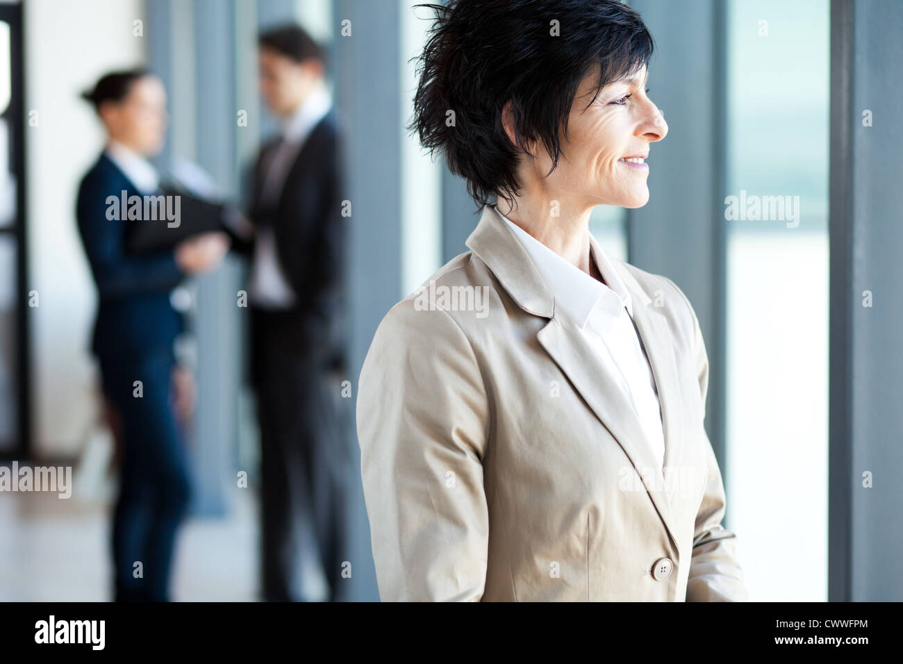 mature businesswoman looking outside office window Stock Photo - Alamy
