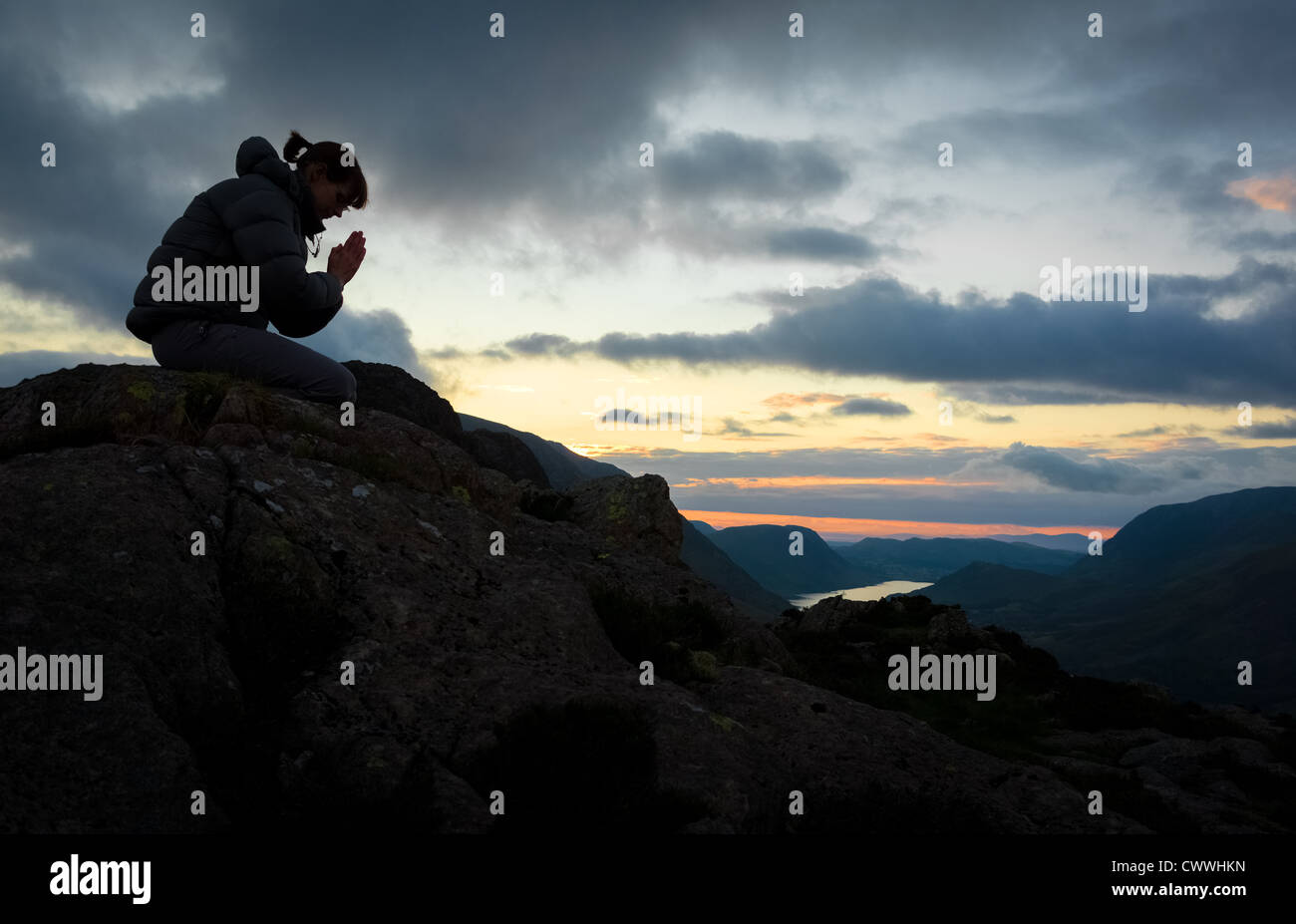 A woman praying to God on the summit of a mountain Stock Photo - Alamy