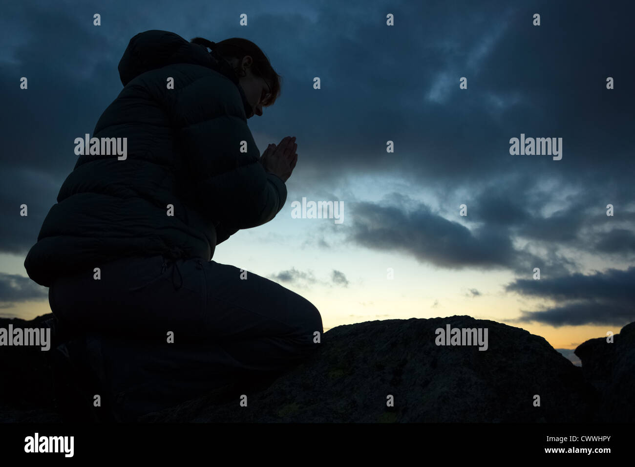 A woman praying to God on the summit of a mountain Stock Photo - Alamy