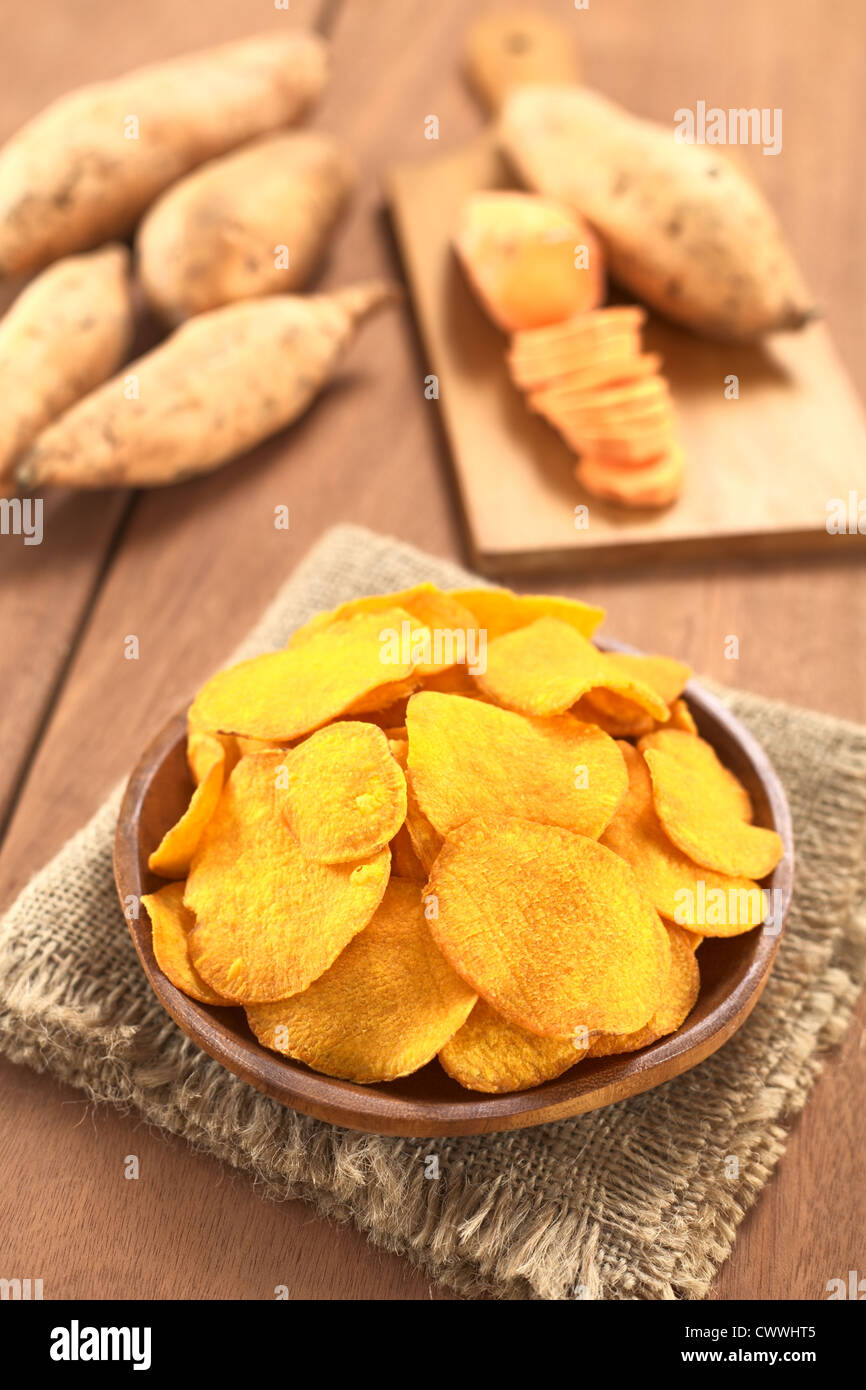 Crispy Peruvian sweet potato chips on wooden plate with sweet potatoes ...