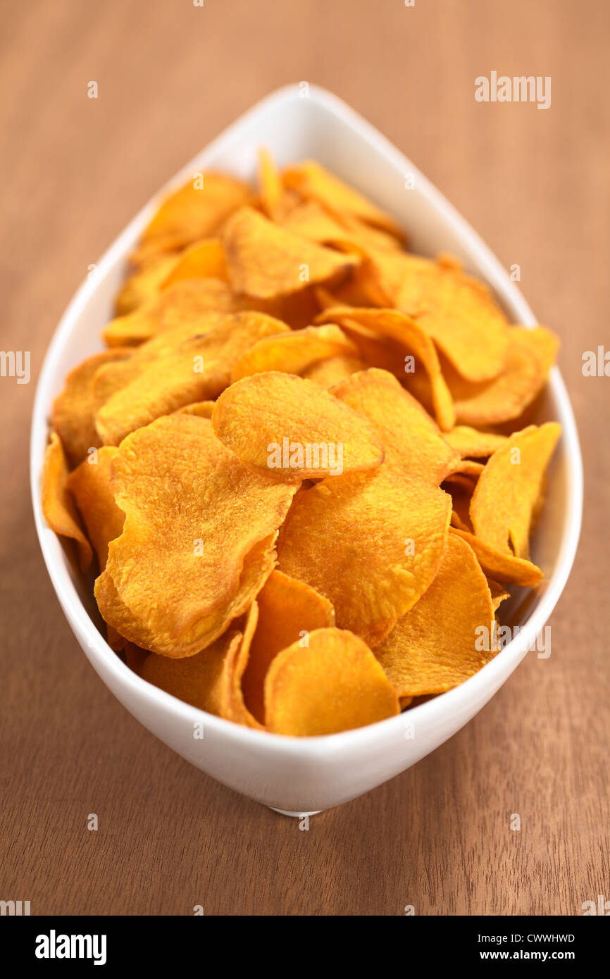 Crispy Peruvian sweet potato chips in white ceramic bowl on wood ...