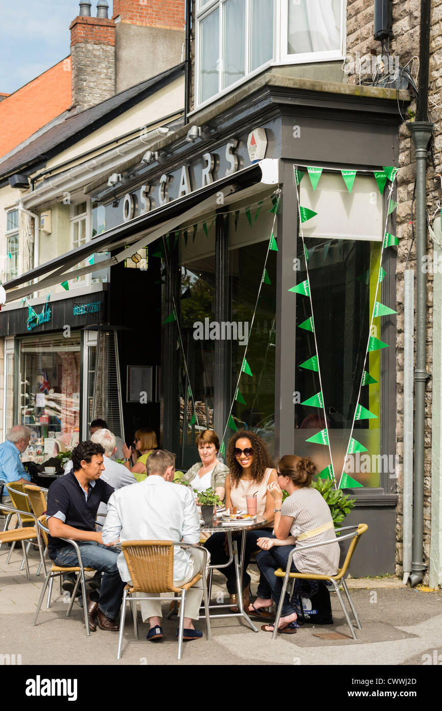 People sitting in the sunshine at outdoor tables of Oscar's cafe bar in ...