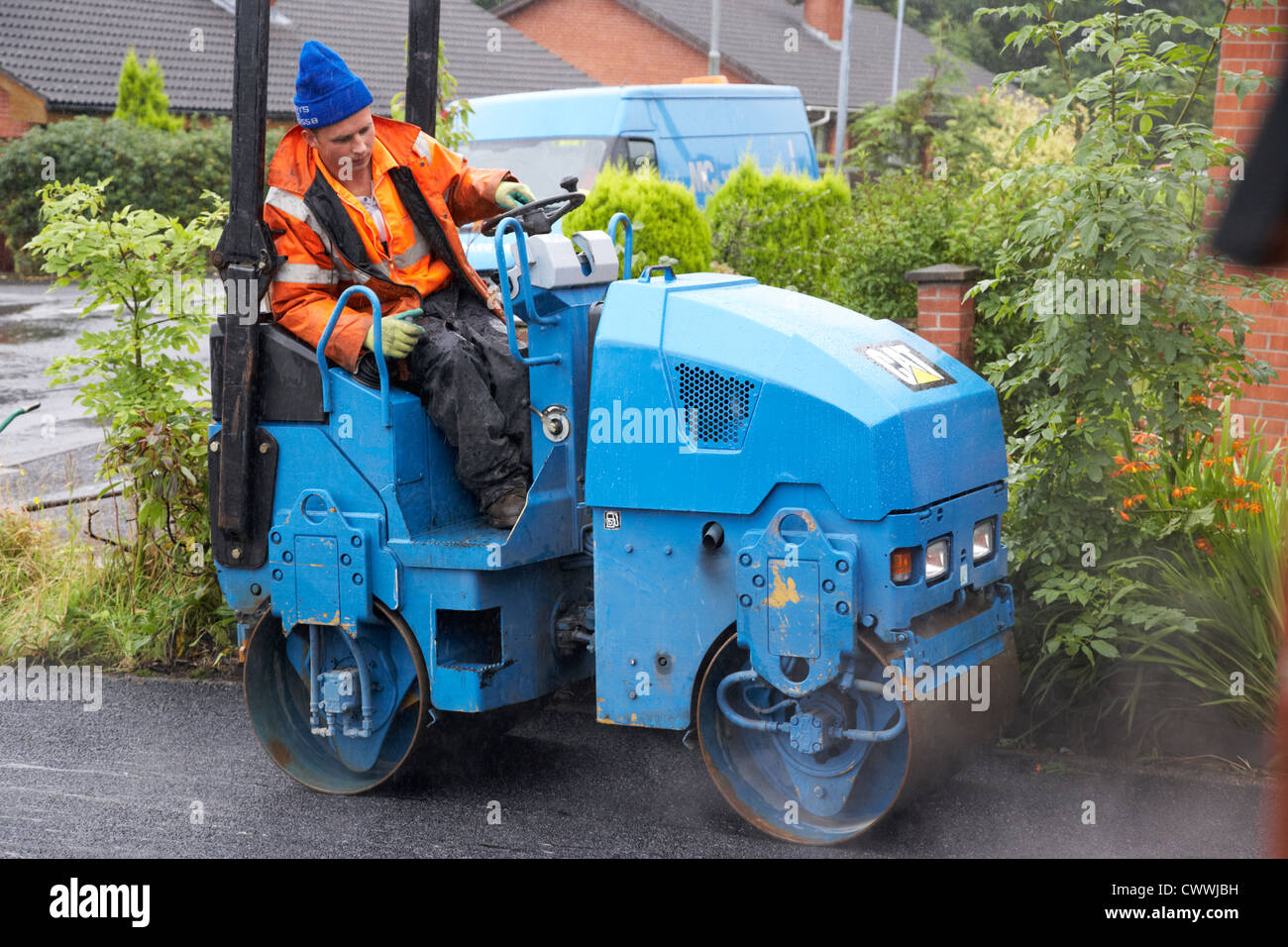 construction worker on a utility roller laying new tarmac driveway in ...