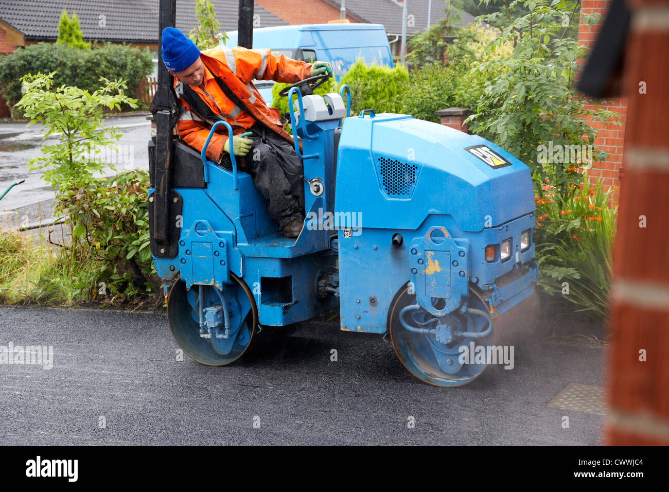 construction worker on a utility roller laying new tarmac driveway in ...