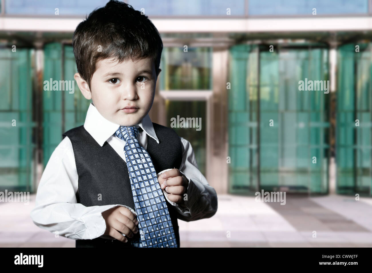 child dressed businessman smiling in front of building Stock Photo - Alamy