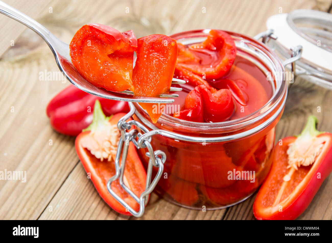 Pickled Paprikas on a fork against wood Stock Photo - Alamy