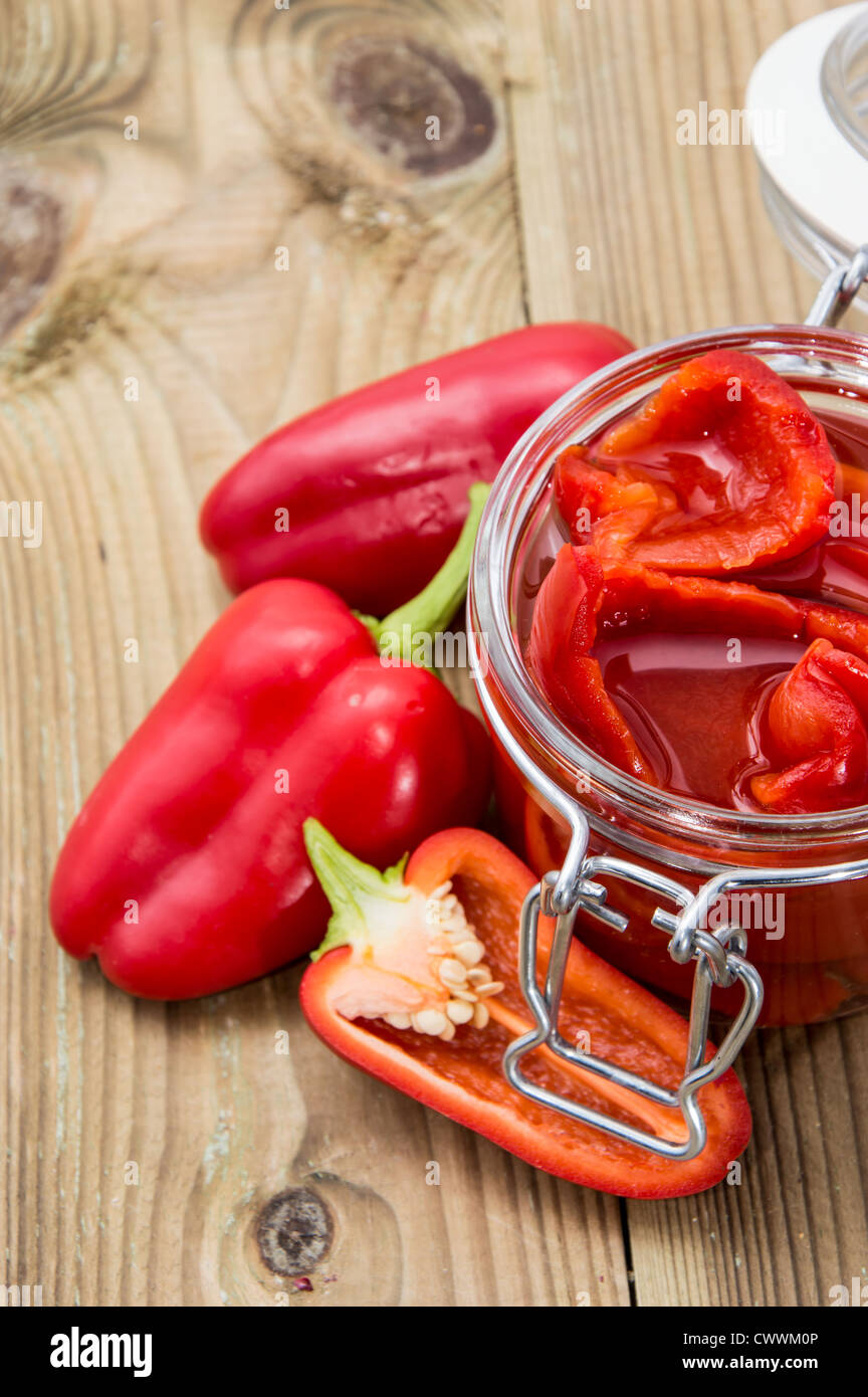 Pickled Paprikas in a glass against wood Stock Photo - Alamy