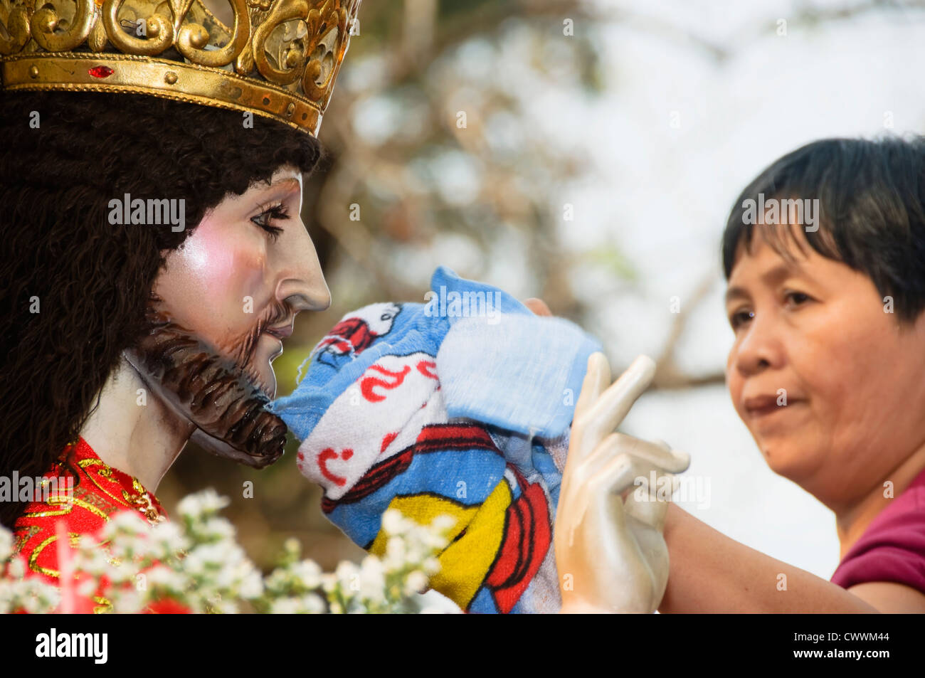 A devotee wipes the face of the statue of the Black Nazarene. Millions ...