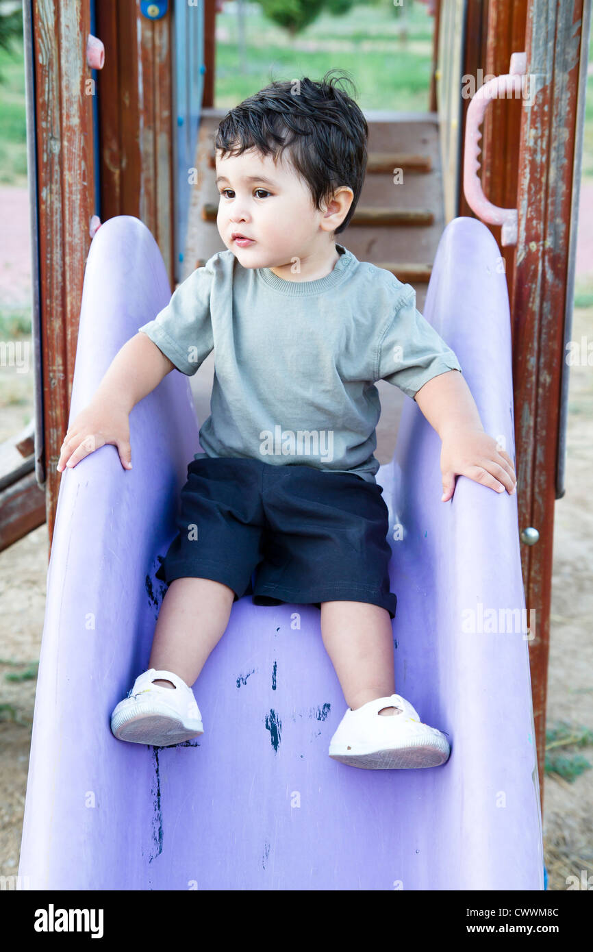 Cute baby playing on sliding board Stock Photo - Alamy