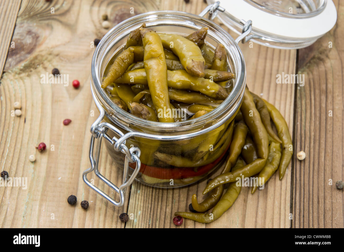 Glass filled with pickled Chilis on wooden background Stock Photo - Alamy