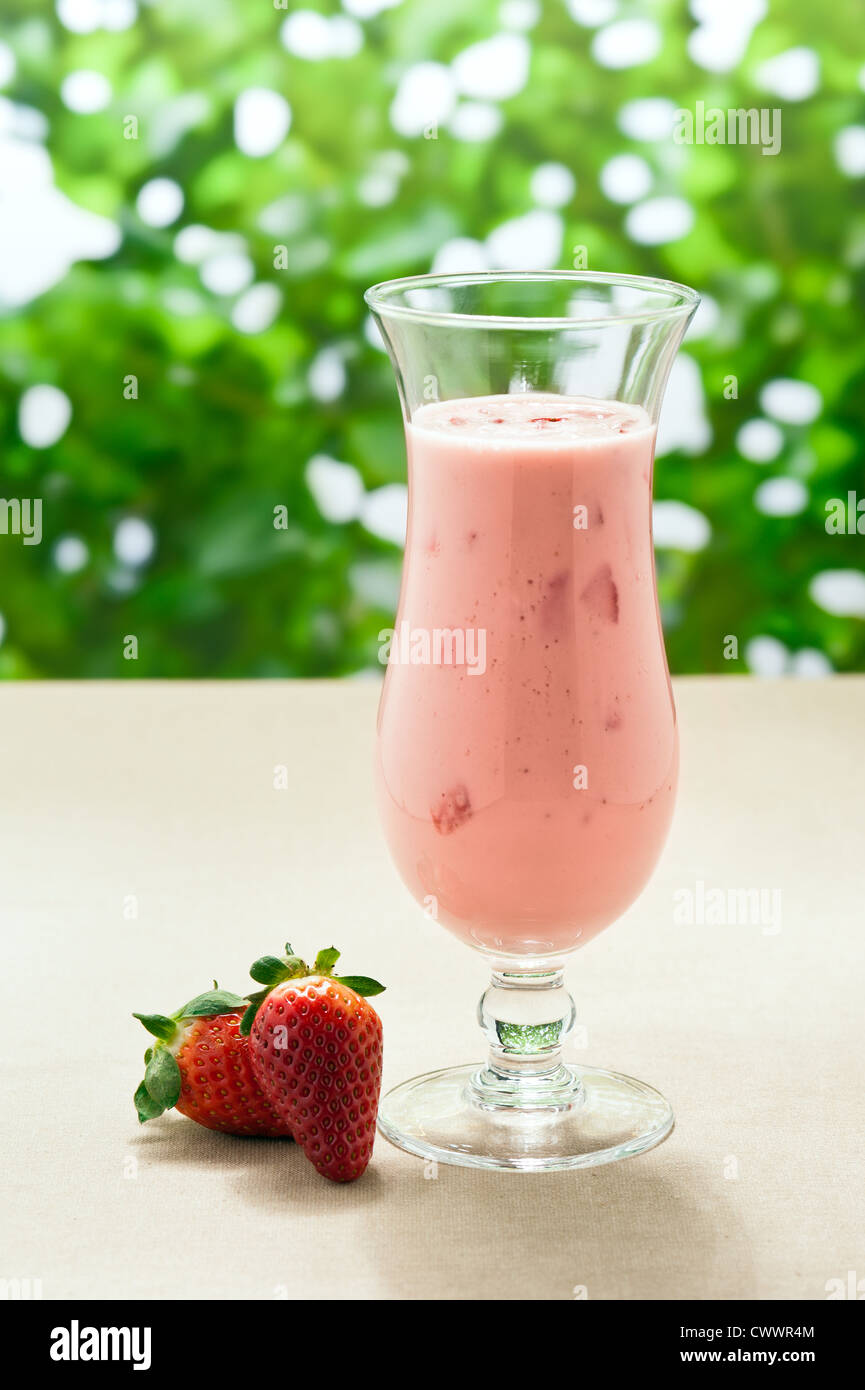 Strawberry milkshake in front of a green background Stock Photo - Alamy