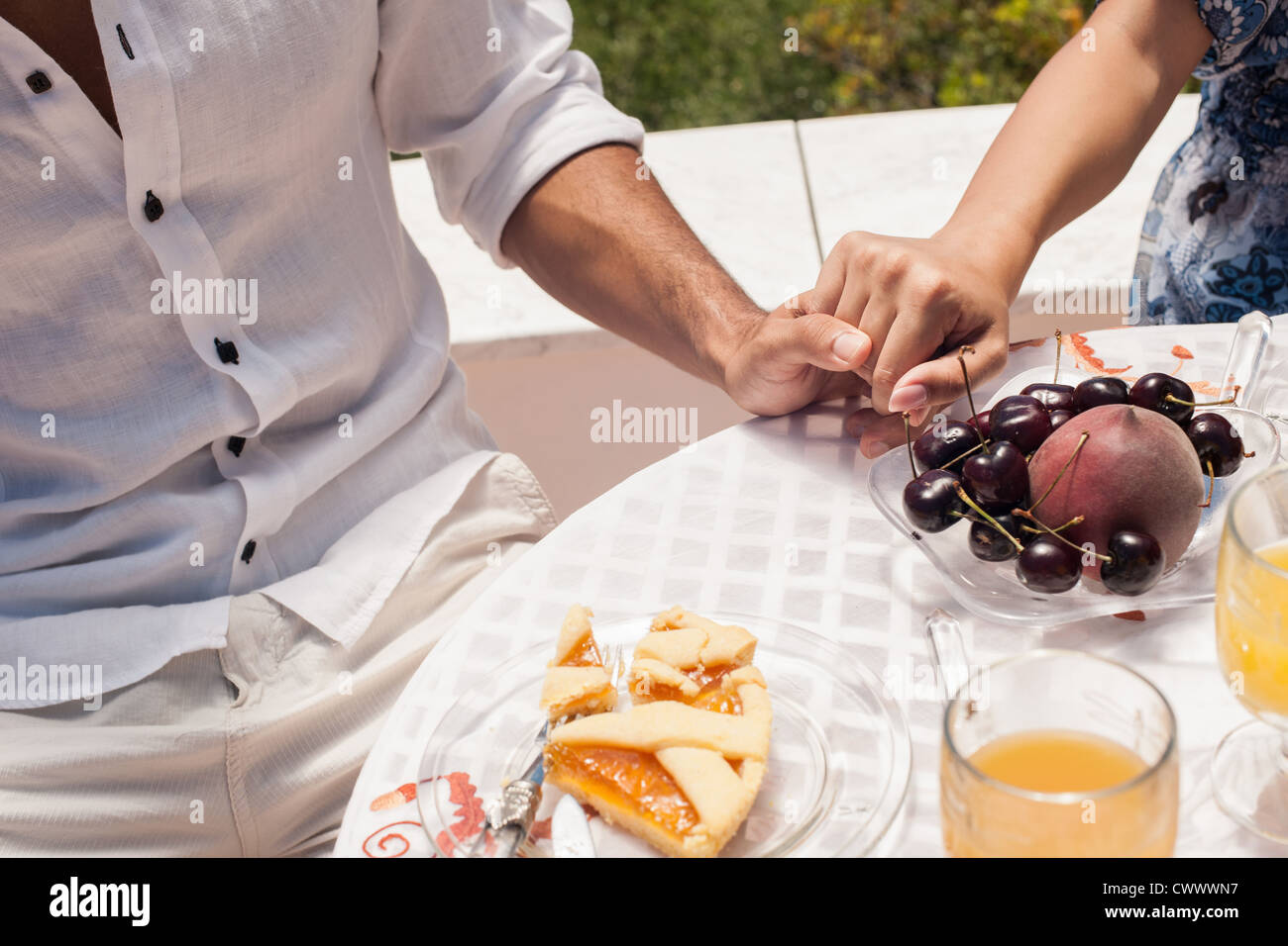 Couple holding hands at table Stock Photo - Alamy