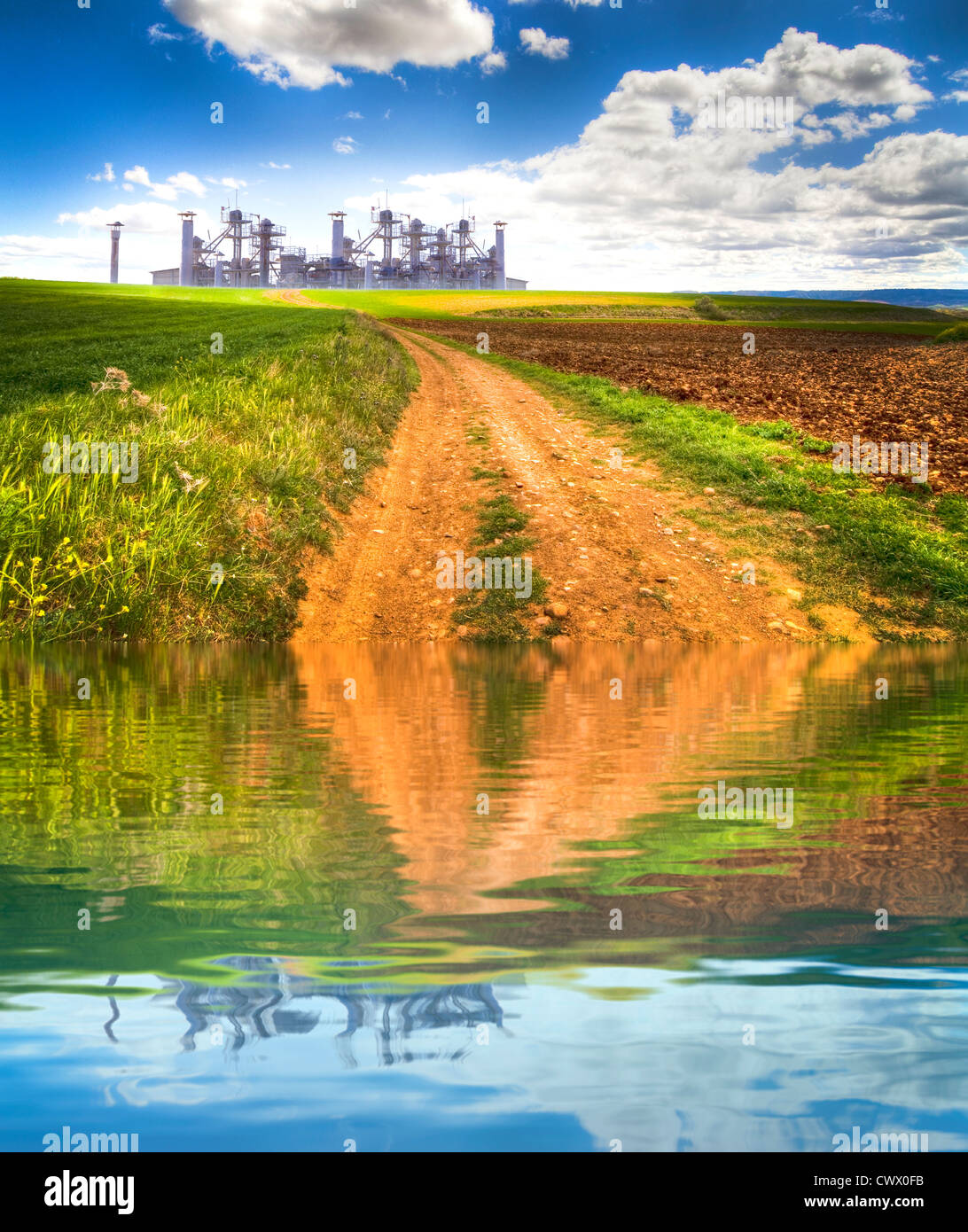 Industry over crop field with water reflection Stock Photo - Alamy
