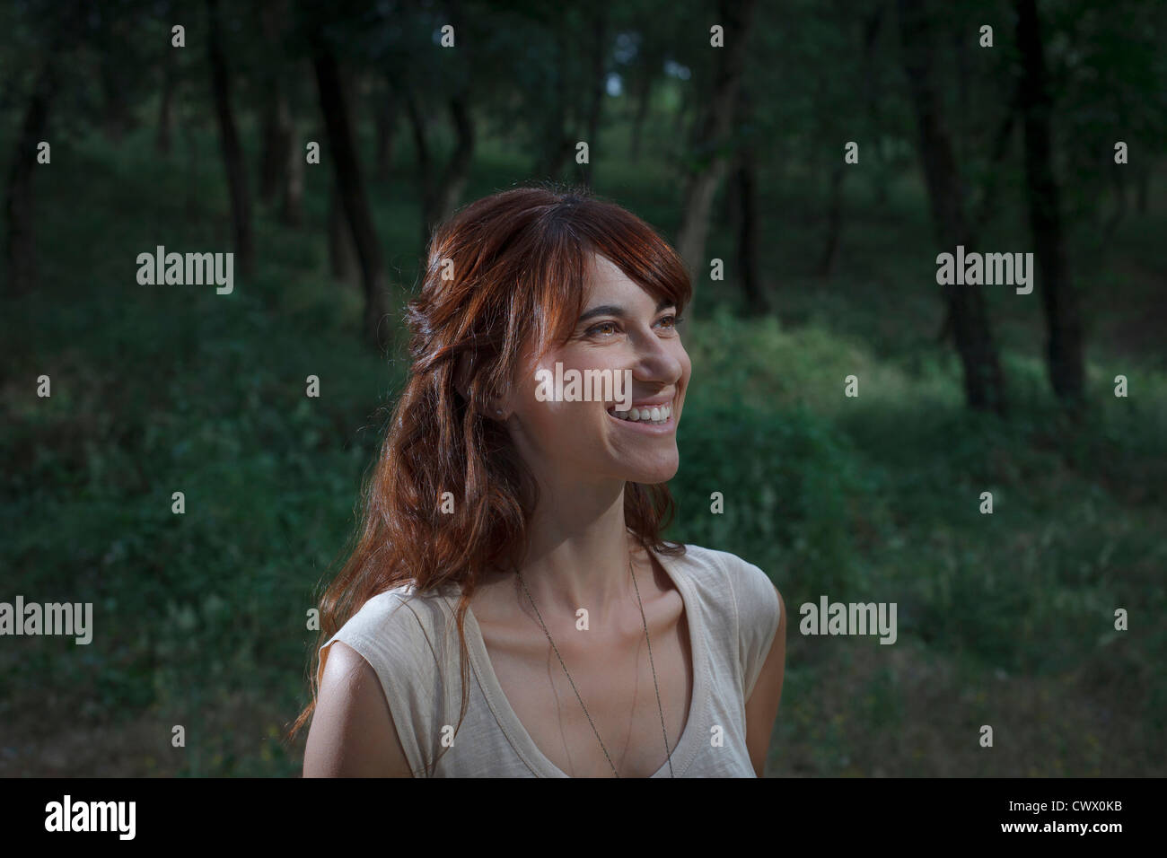 Smiling woman standing in forest Stock Photo - Alamy