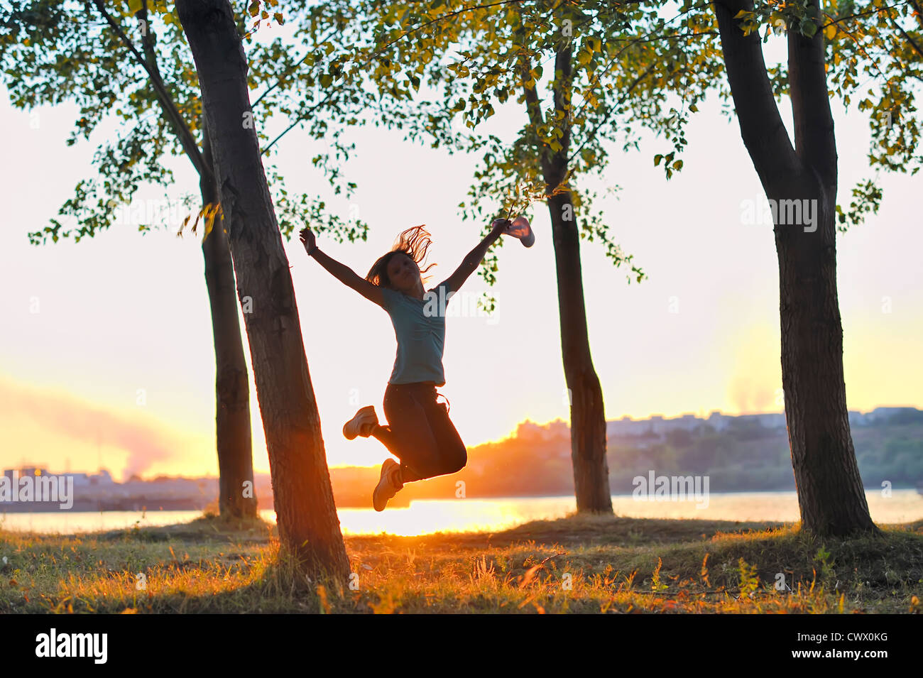 girl jumping over sunset Stock Photo - Alamy