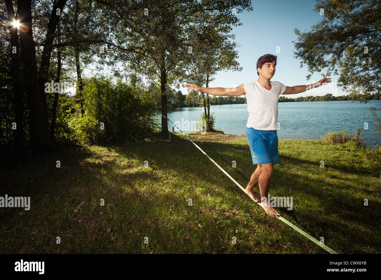 Man walking on tight rope outdoors Stock Photo - Alamy