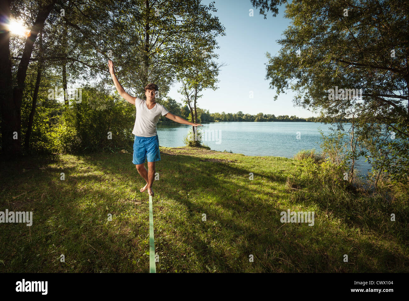 Man walking on tight rope outdoors Stock Photo - Alamy