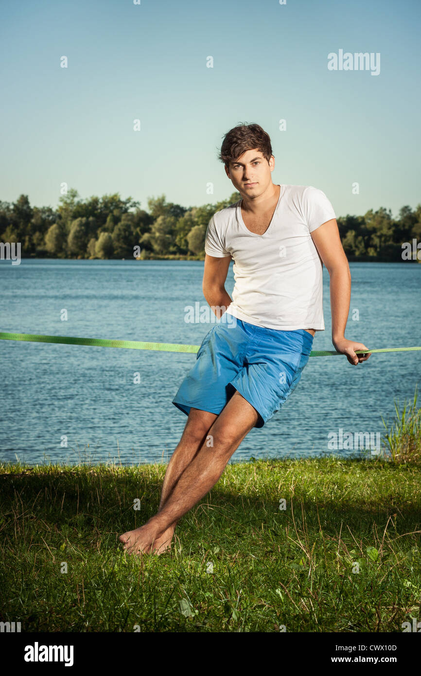 Man sitting on tight rope outdoors Stock Photo - Alamy