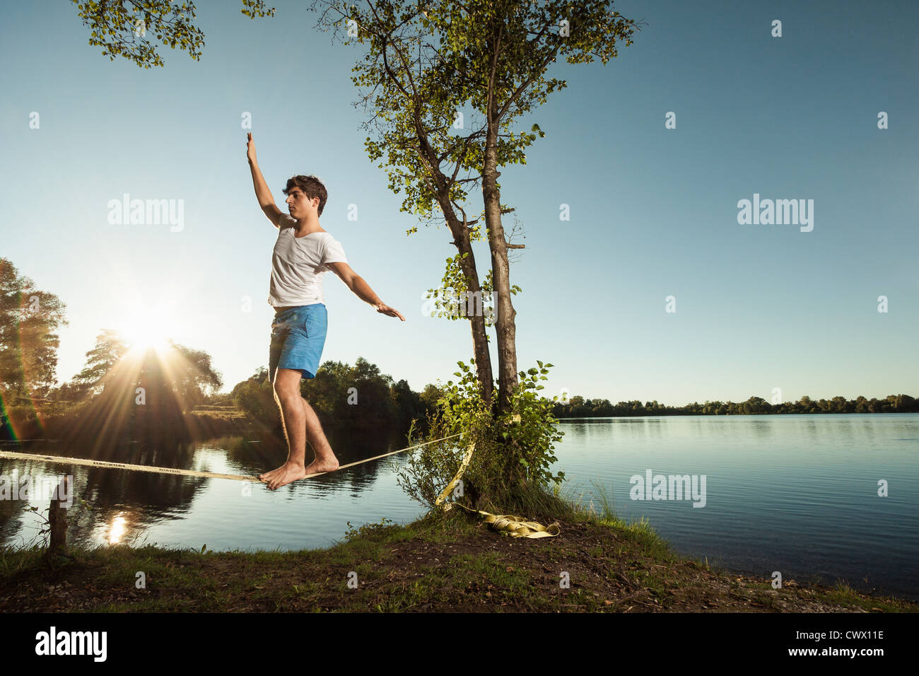 Man walking on tight rope outdoors Stock Photo - Alamy