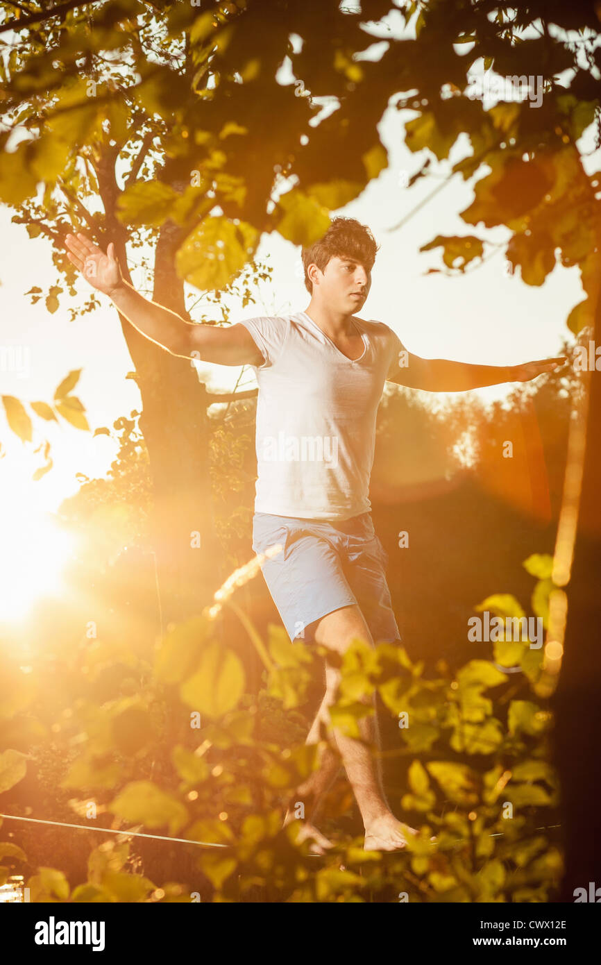 Man walking on tight rope outdoors Stock Photo - Alamy