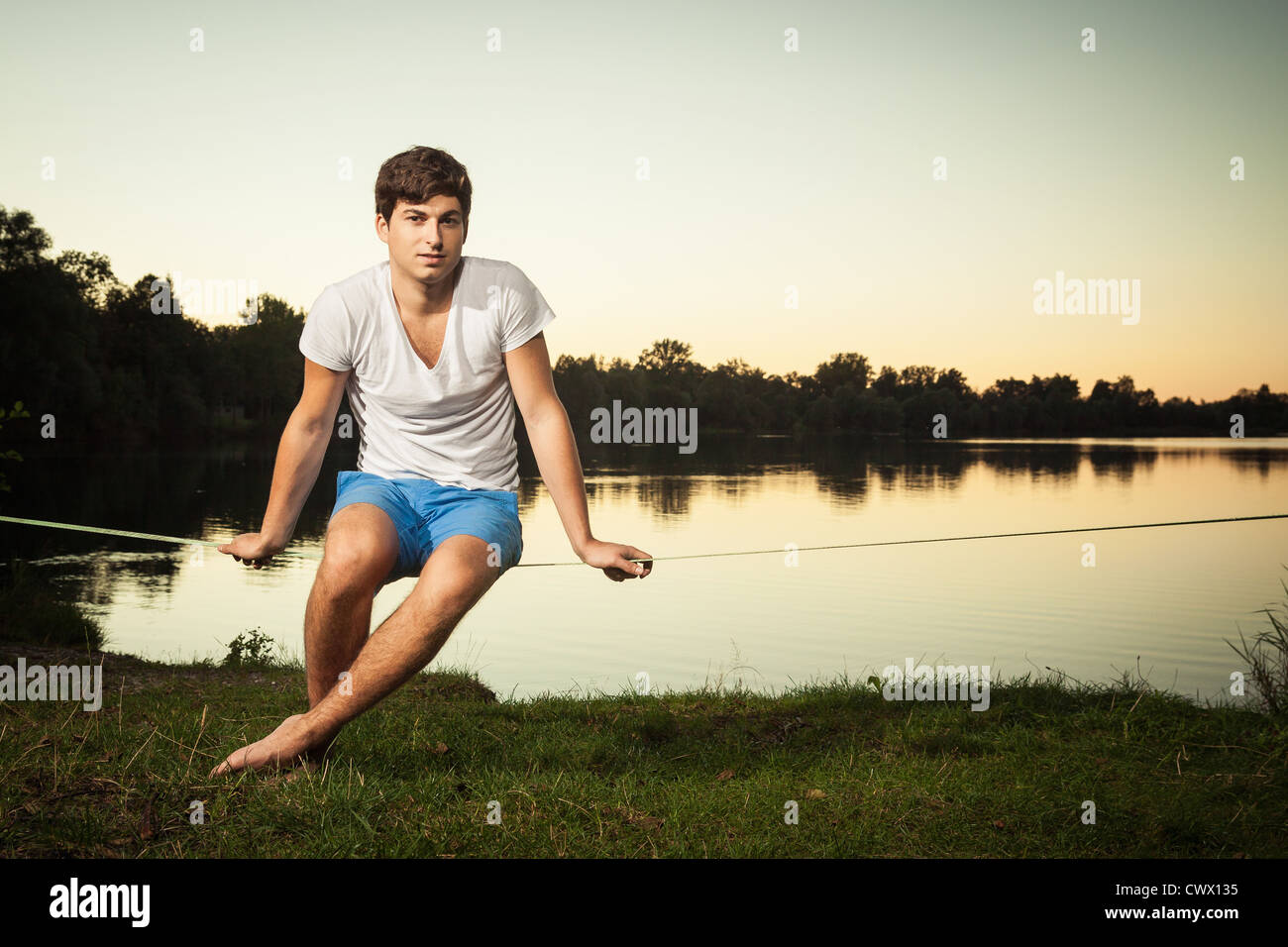 Man sitting on tight rope outdoors Stock Photo - Alamy