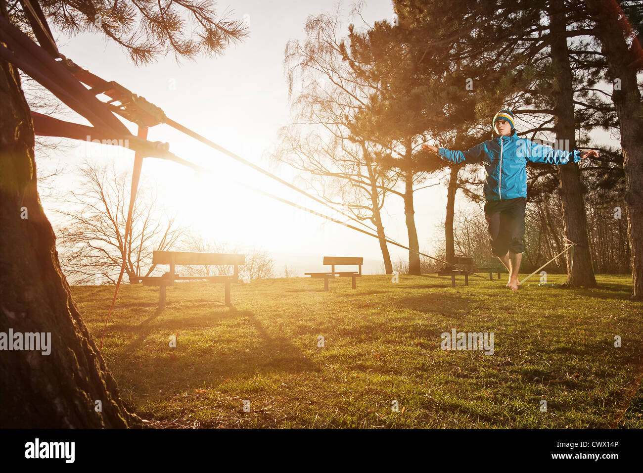 Man walking on tight rope outdoors Stock Photo - Alamy