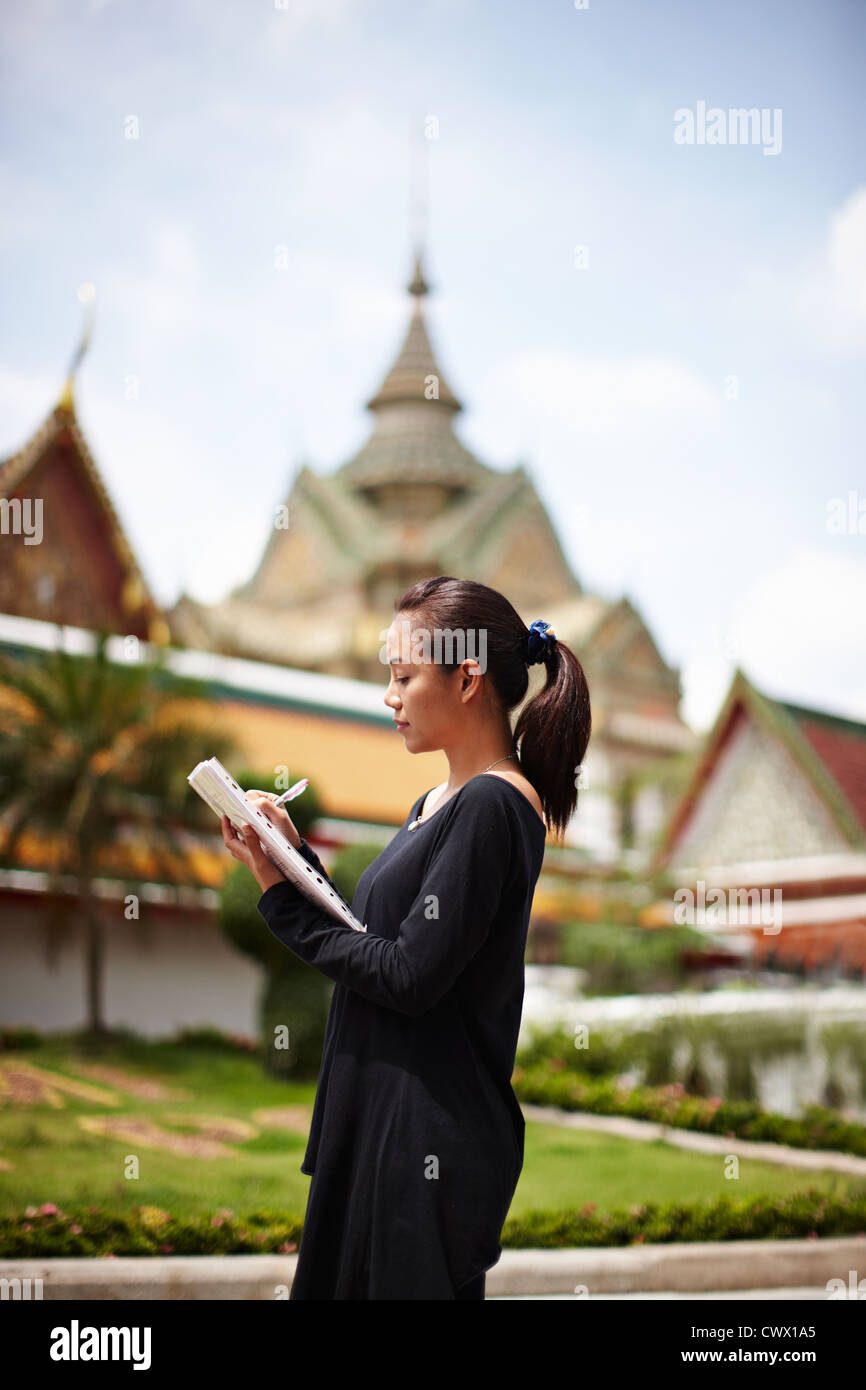 Woman writing outside ornate temple Stock Photo - Alamy