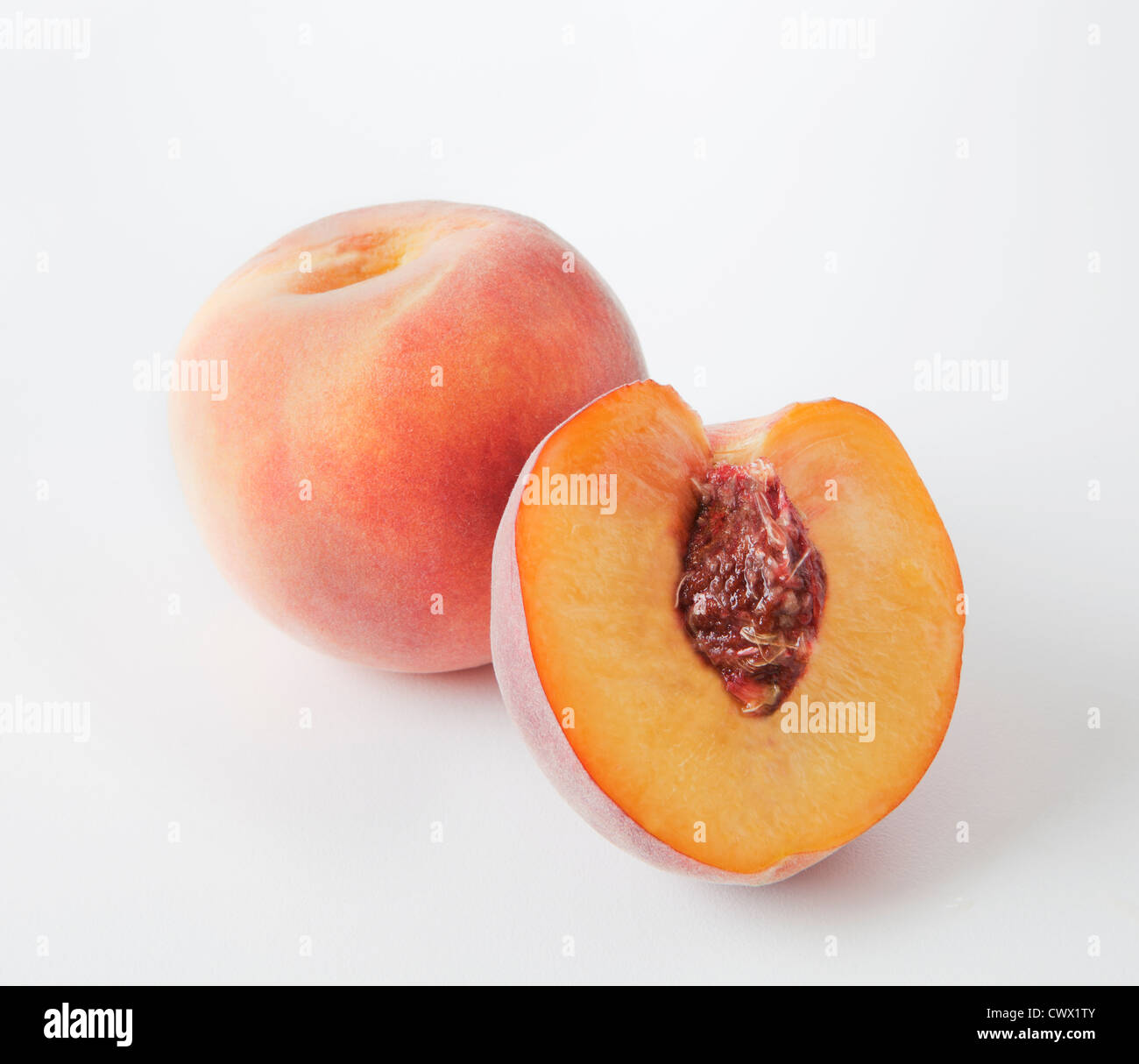 Still life of a peach and half a cut peach on a white background Stock ...