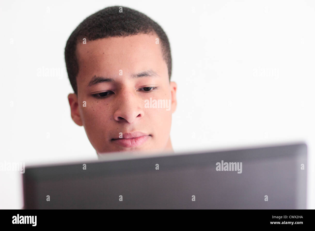 Teenage boy using laptop indoors Stock Photo - Alamy
