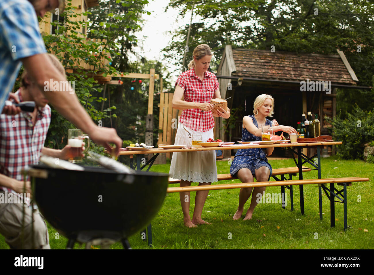 Friends setting table outdoors Stock Photo - Alamy