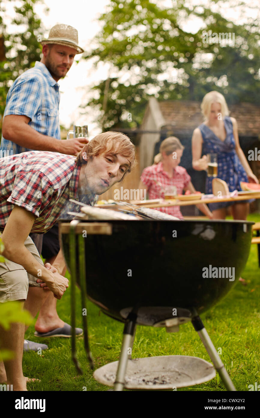 Man grilling fish on barbecue outdoors Stock Photo - Alamy