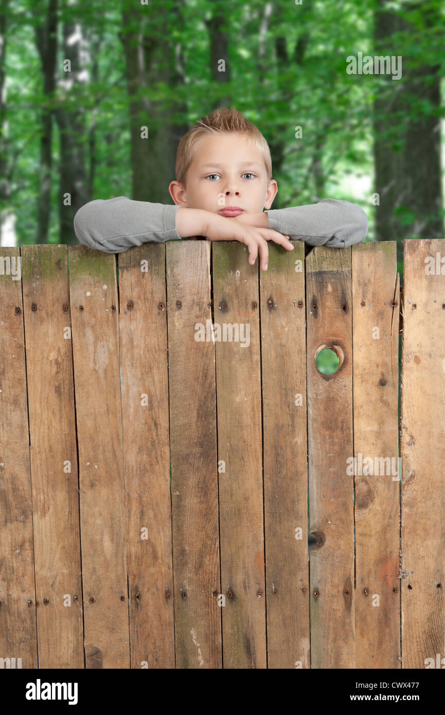 boy looking from above a fence. Wood landscape Stock Photo - Alamy