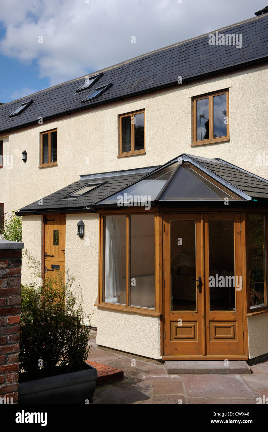 A renovated cottage with matching render slate tiles and stained wood ...