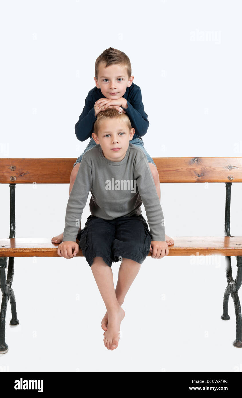 brothers seated on a bench, isolated on grey Stock Photo - Alamy