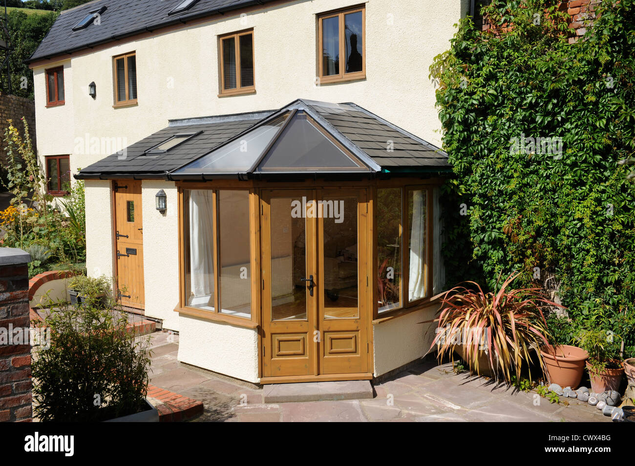 A renovated cottage with matching render slate tiles and stained wood ...