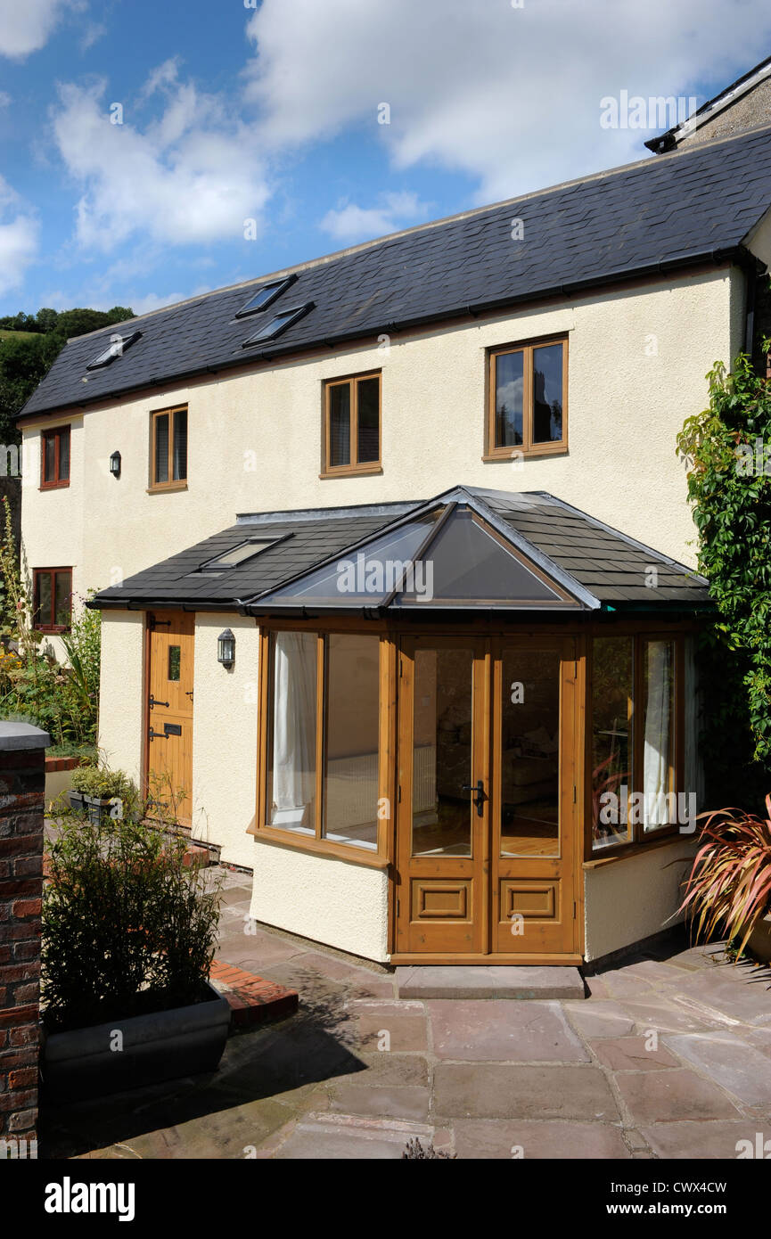 A renovated cottage with matching render slate tiles and stained wood ...