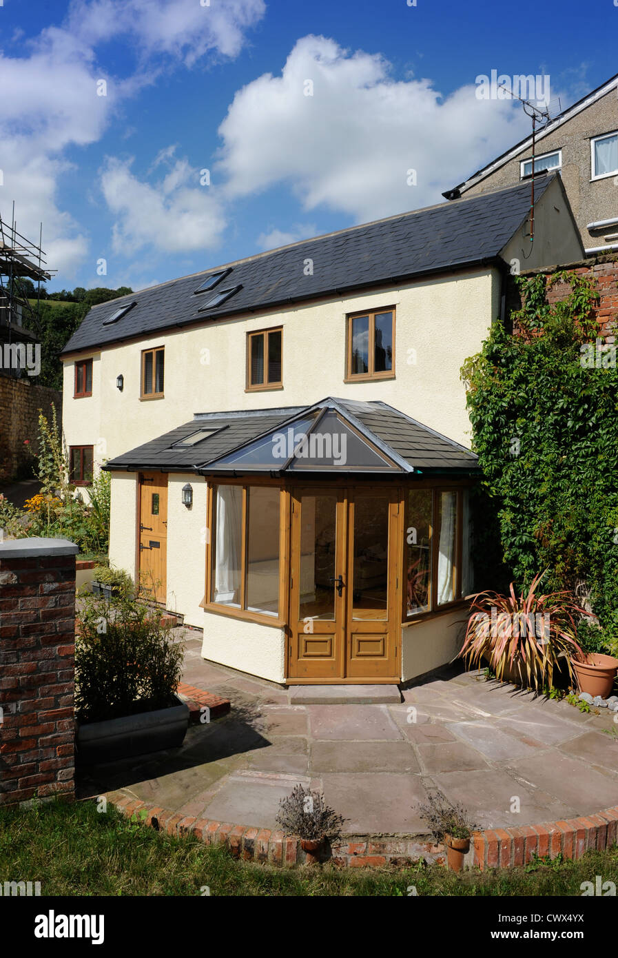 A renovated cottage with matching render slate tiles and stained wood ...