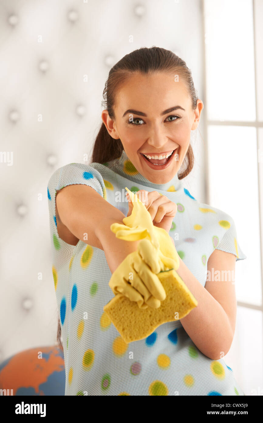 Attractive brunette woman playfully pulling off bright yellow rubber ...