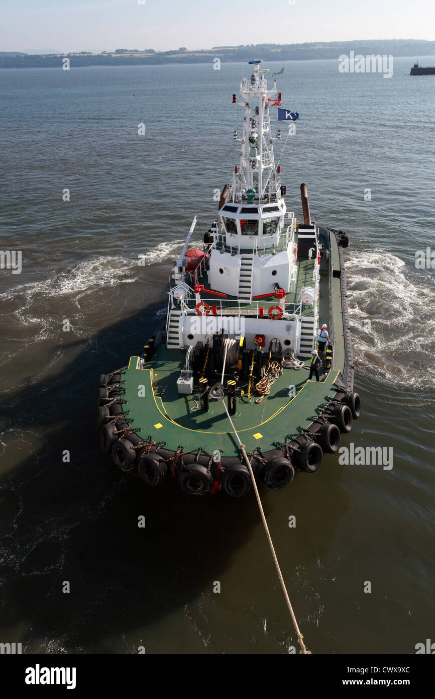 Tugboat in action pulling a large cruise liner into deeper water in ...