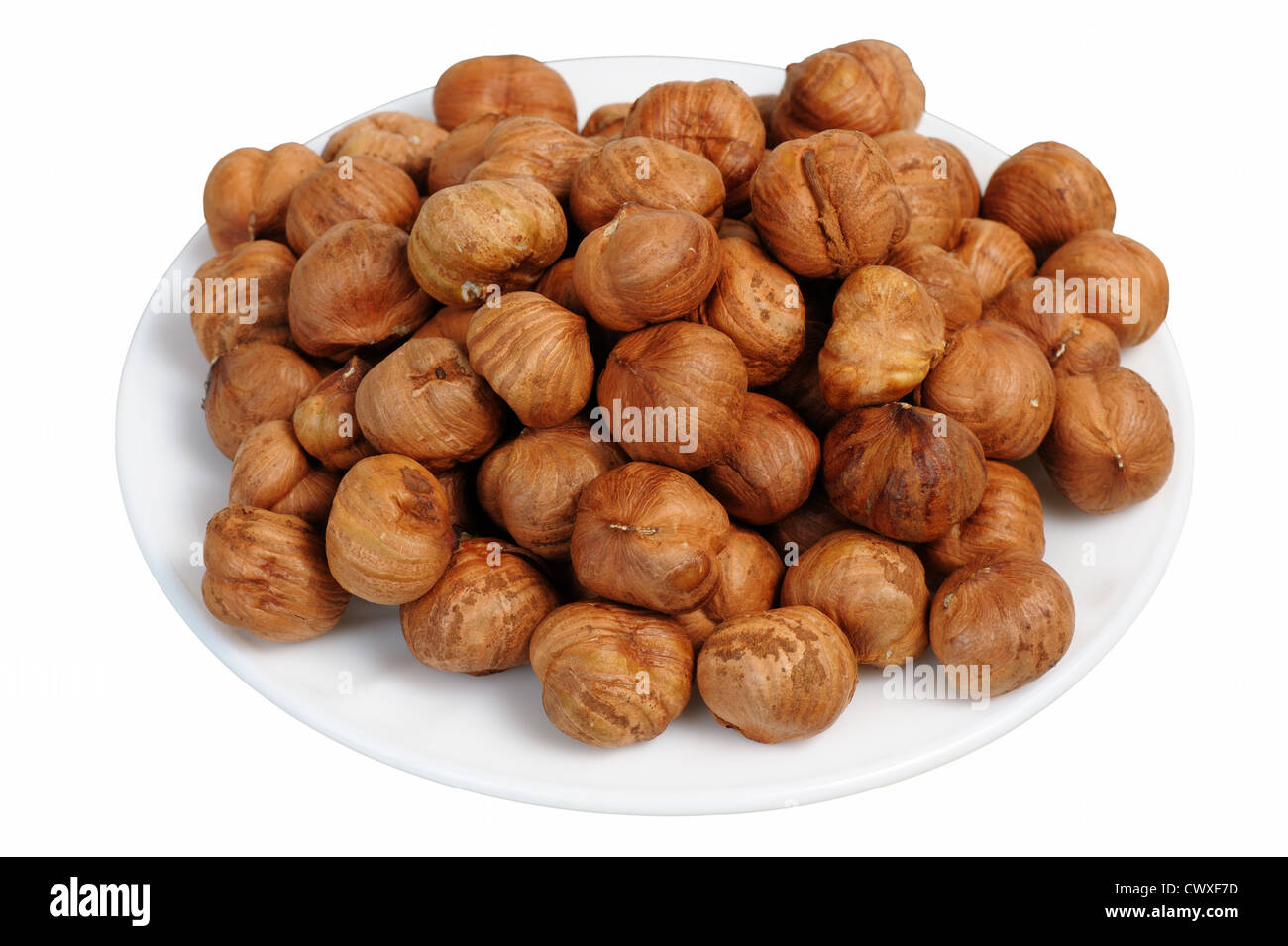 Hazelnuts on a white plate on a white background, isolated Stock Photo ...