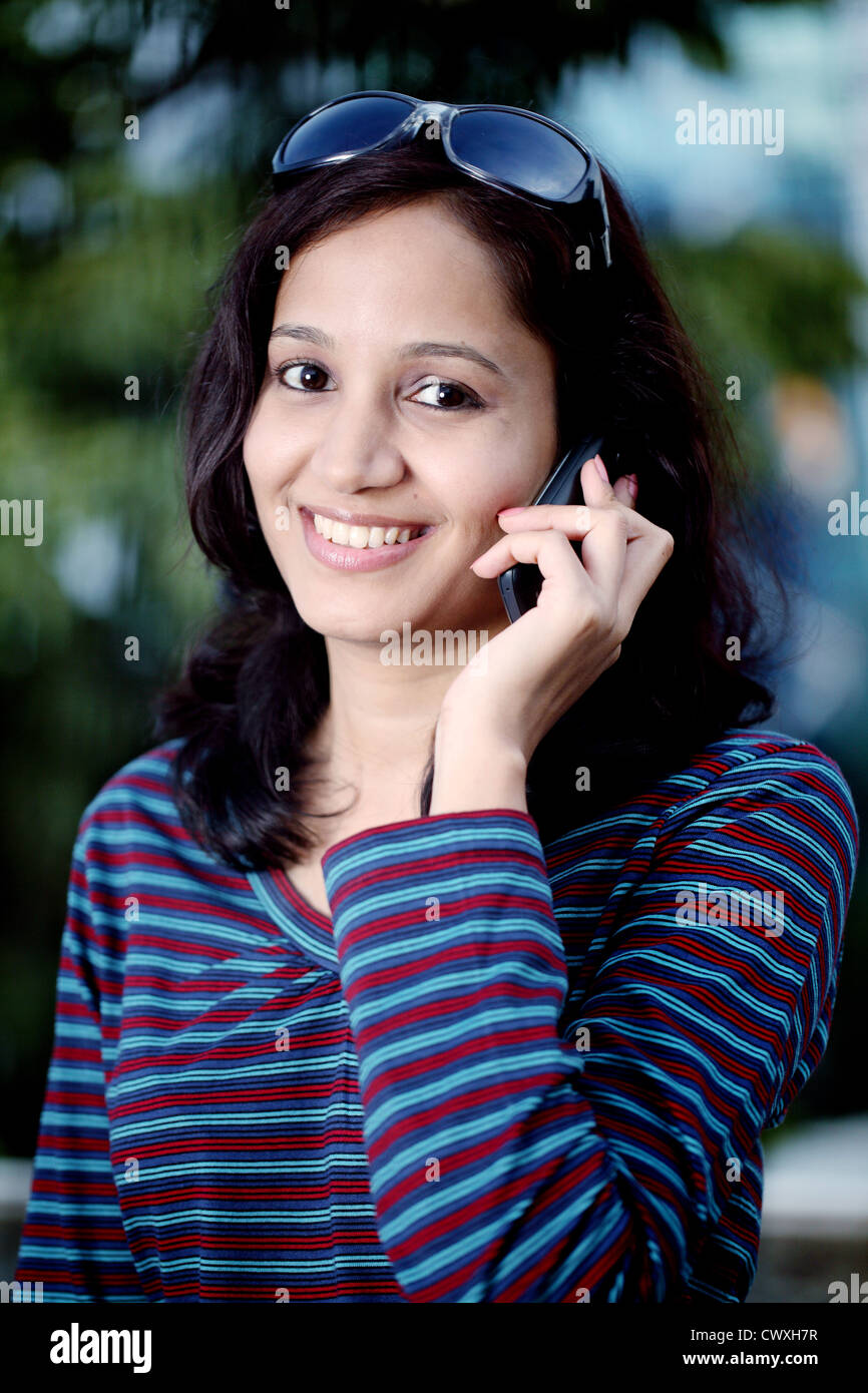 Attractive smiling Indian girl talking on cellphone Stock Photo - Alamy
